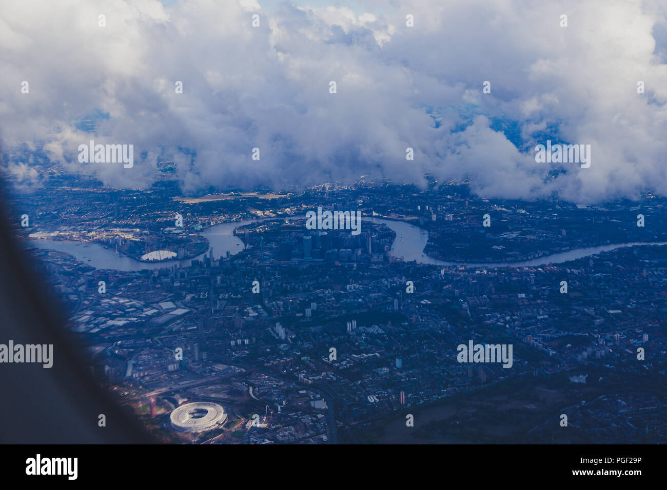 aerial view of the city of London from airplane window seat approaching ...