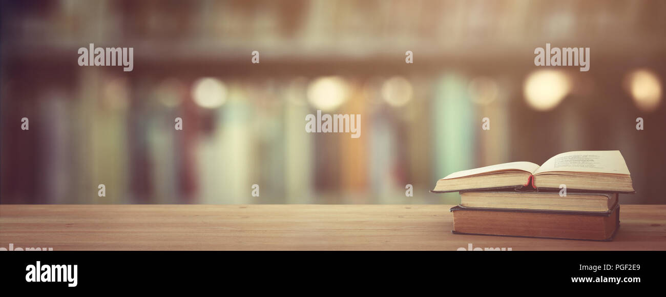 back to school concept. stack of books over wooden desk in front of ...