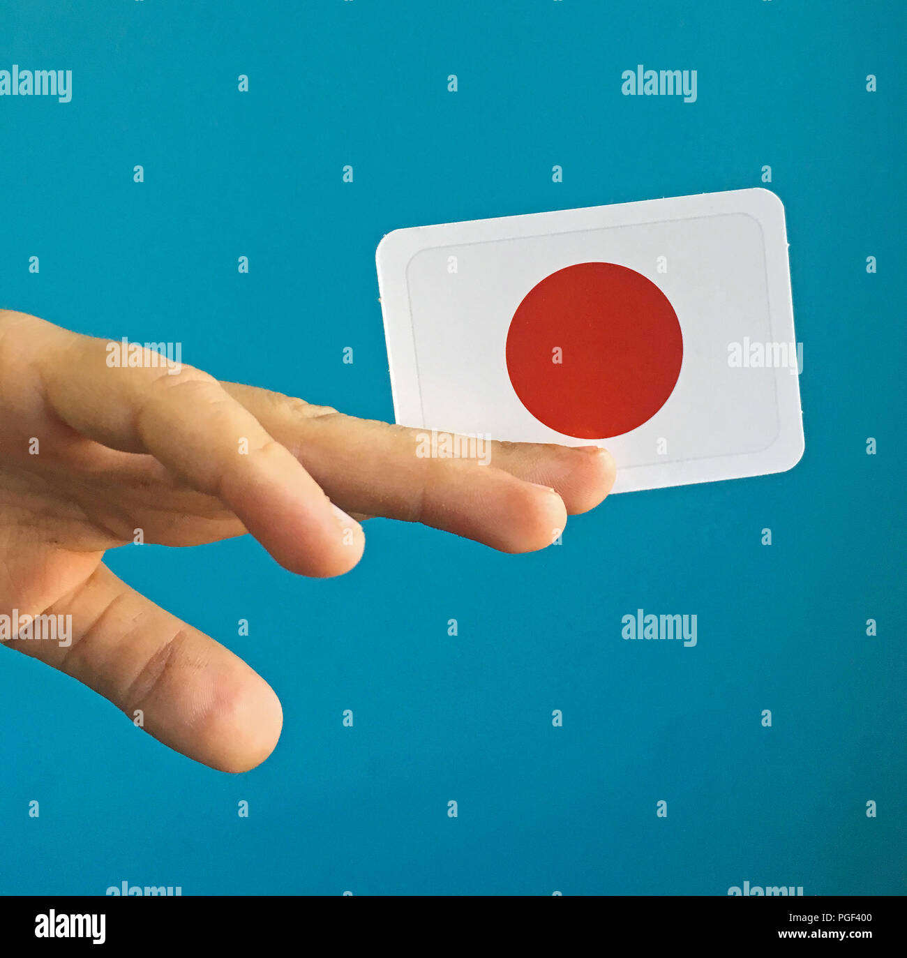 Paper card with japanese flag on blue background Stock Photo - Alamy