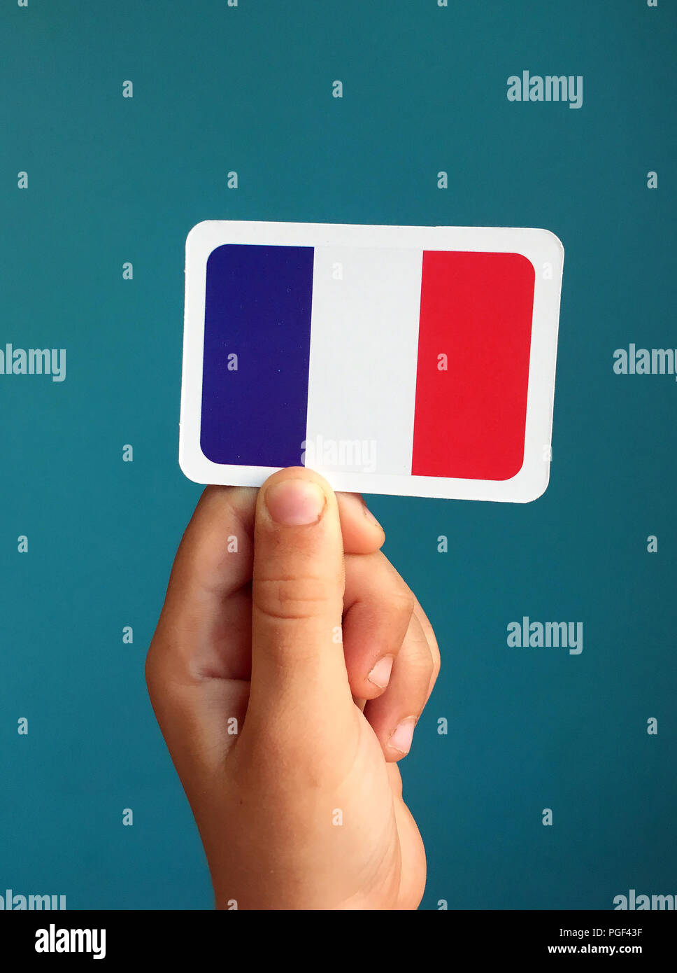 Little french flag in the hand on blue background Stock Photo - Alamy