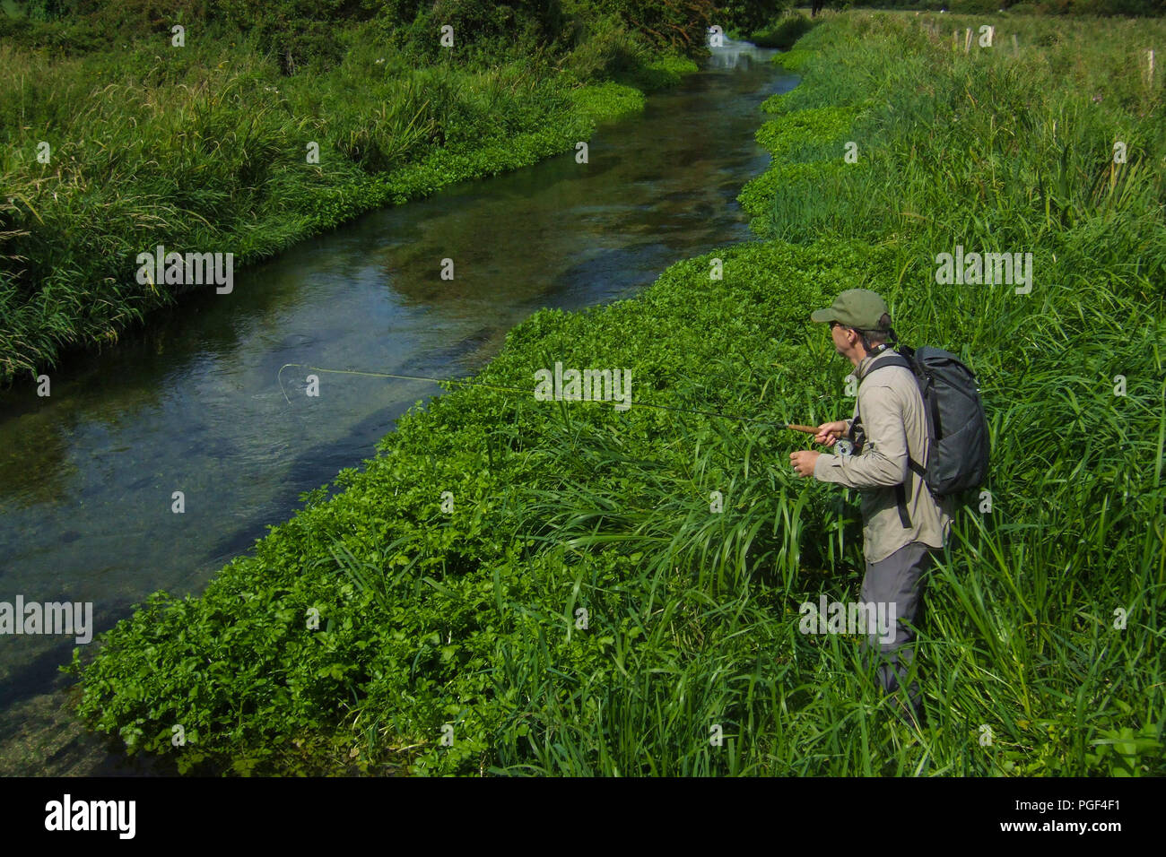 A fly fisherman stalks a fish on the famous River Itchen in Hampshire ...