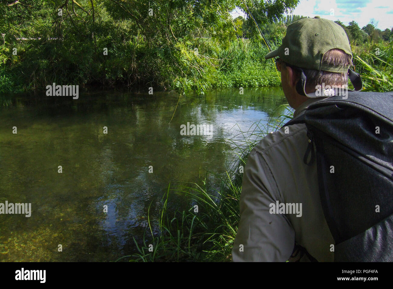 A fly fisherman stalks a fish on the famous River Itchen in Hampshire ...