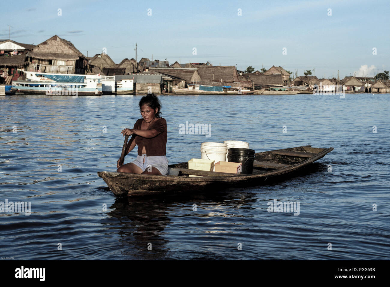 Woman padding wooden canoe along river in Belen, Iquitos, Peru Stock ...