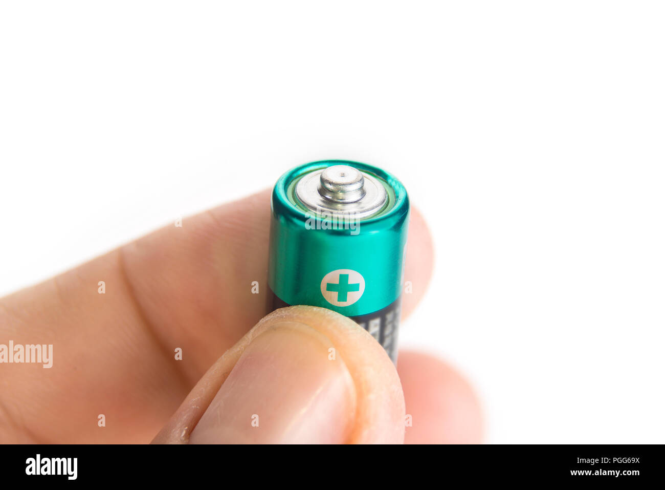 Tip of the fingers holds alkaline battery Stock Photo - Alamy