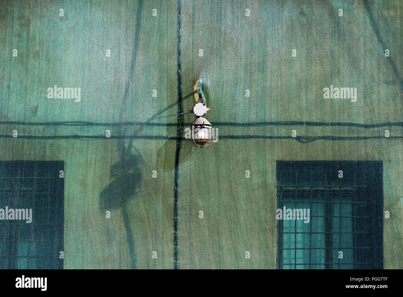 The green building mesh on old house with windows protects the old ...