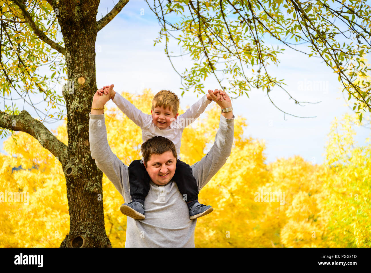 Father giving his son piggyback ride in autumn park, Adelaide Hills ...