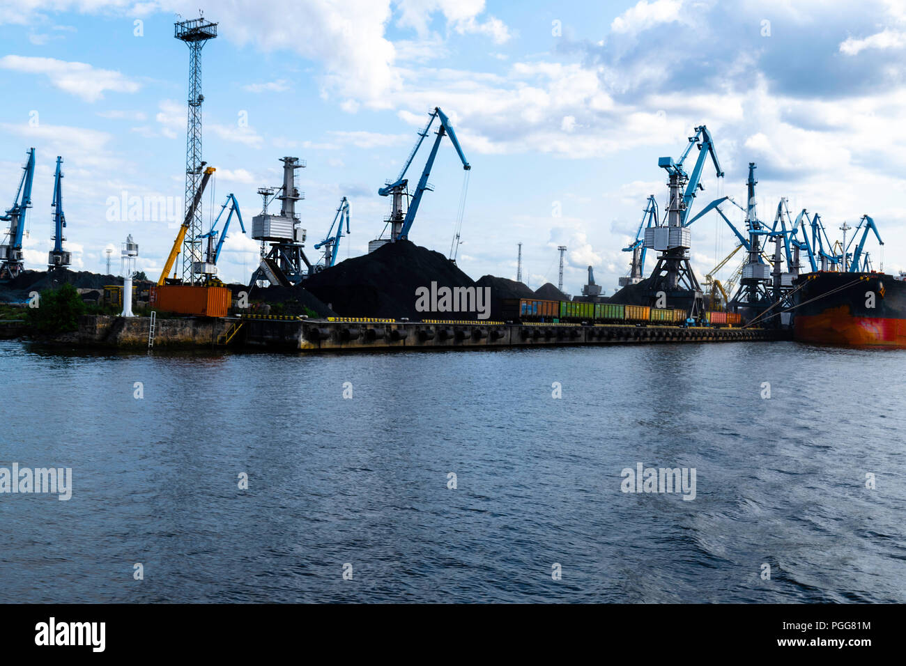 Large red cargo ship loading with a coal in the port, terminal, crane ...