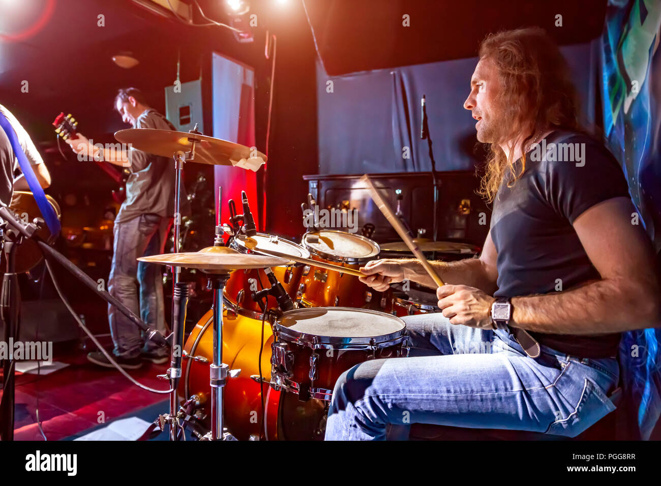 Drummer playing on drum set on stage. Authentic shooting with high iso ...
