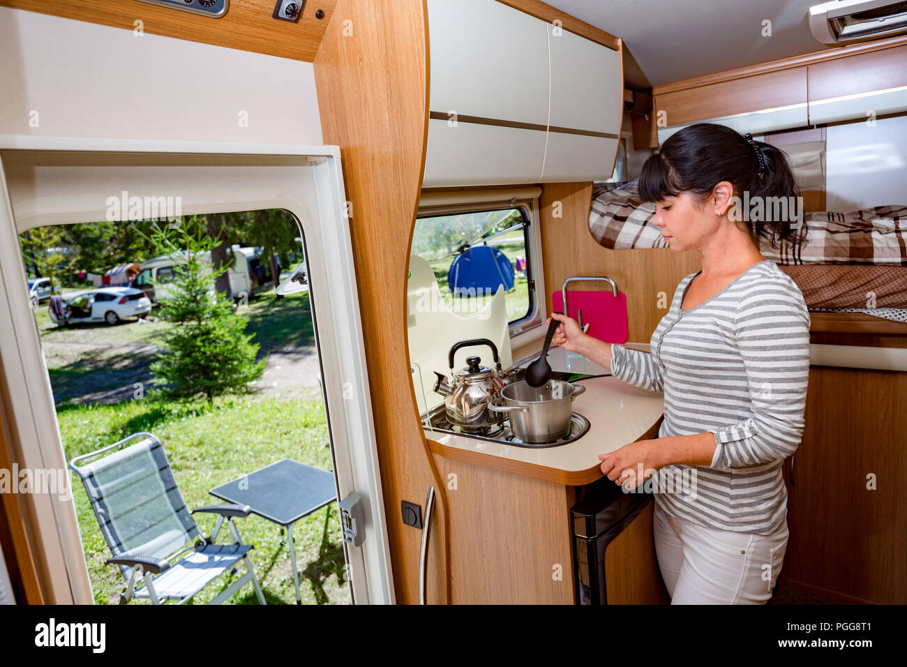 Woman cooking in camper, motorhome RV interior. Family vacation travel ...