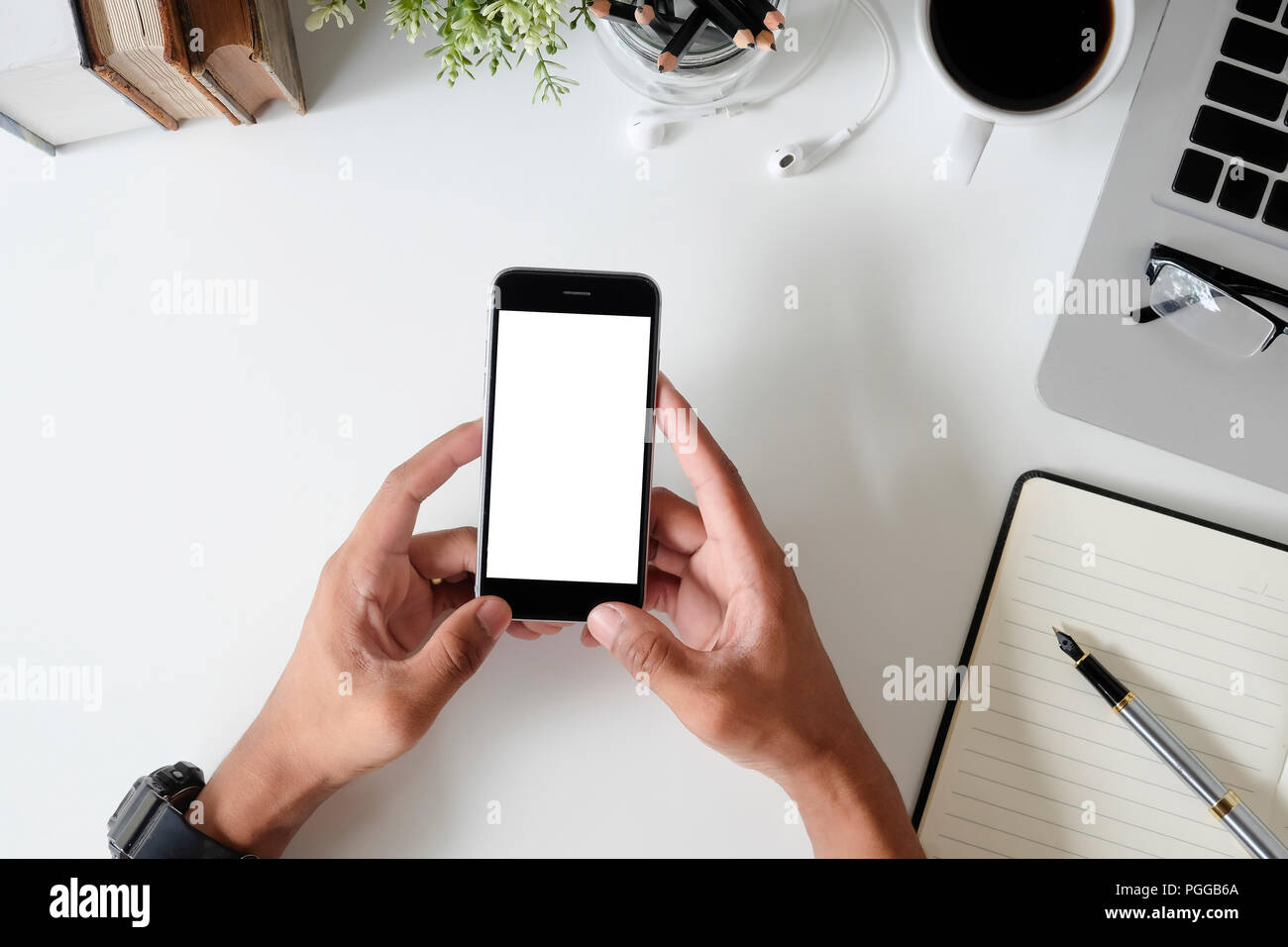 Top view office desk with mockup smartphone on hands with empty display ...