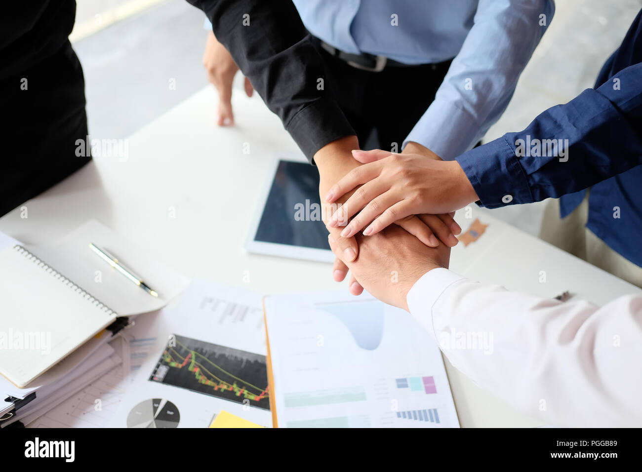 Close up young business people putting their hands together. Stack of hands on office workplace ...
