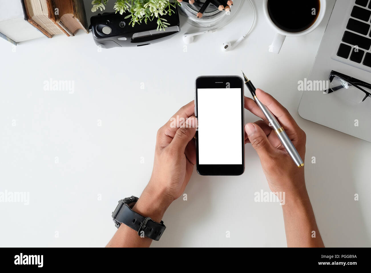 Top view office desk with mockup smartphone on hands with empty display ...
