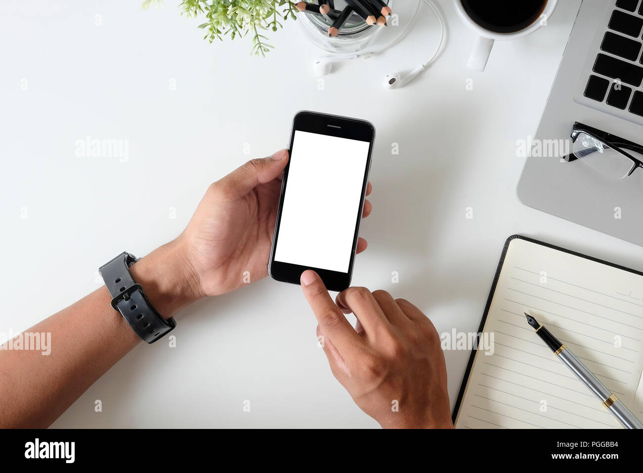 Top view office desk with mockup smartphone on hands with empty display ...
