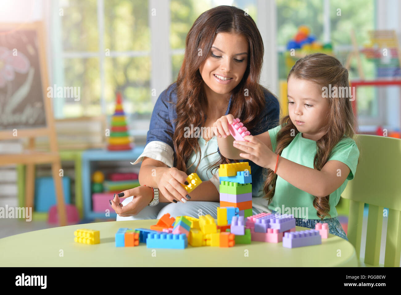 Portrait of a little girl playing with mother Stock Photo - Alamy