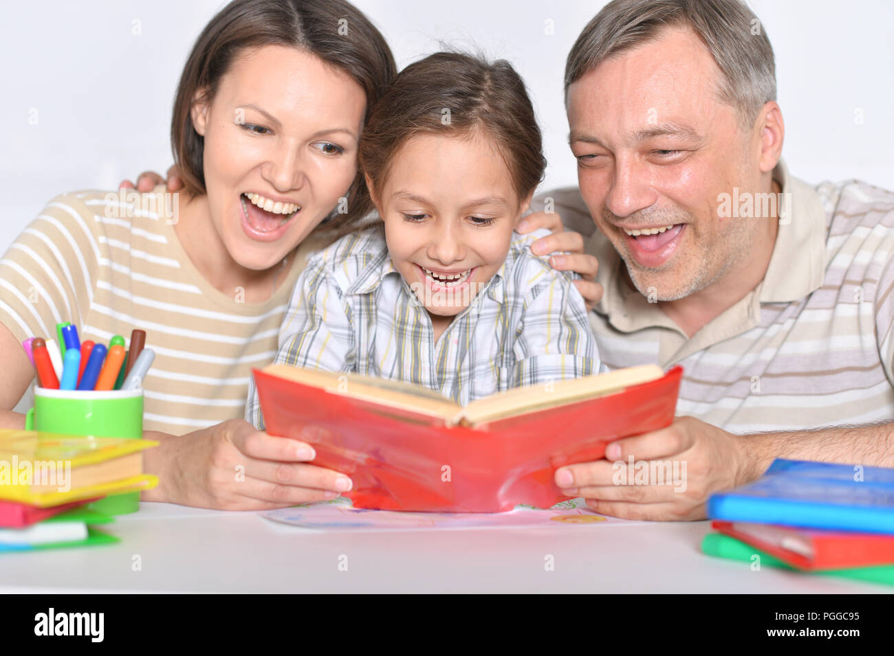 Portrait of parents with little daughter doing homework Stock Photo - Alamy