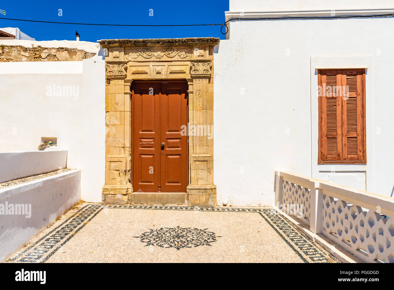 Greek architecture with traditional doors and decorative pavement in ...