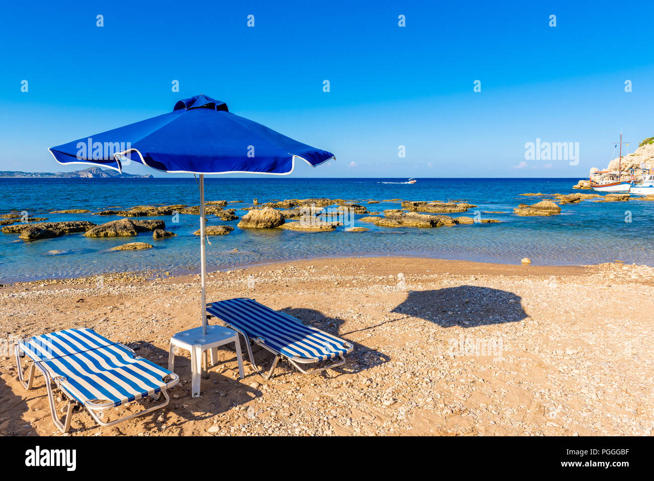 Sun loungers with umbrella on beautiful Kolymbia beach. Rhodes island ...
