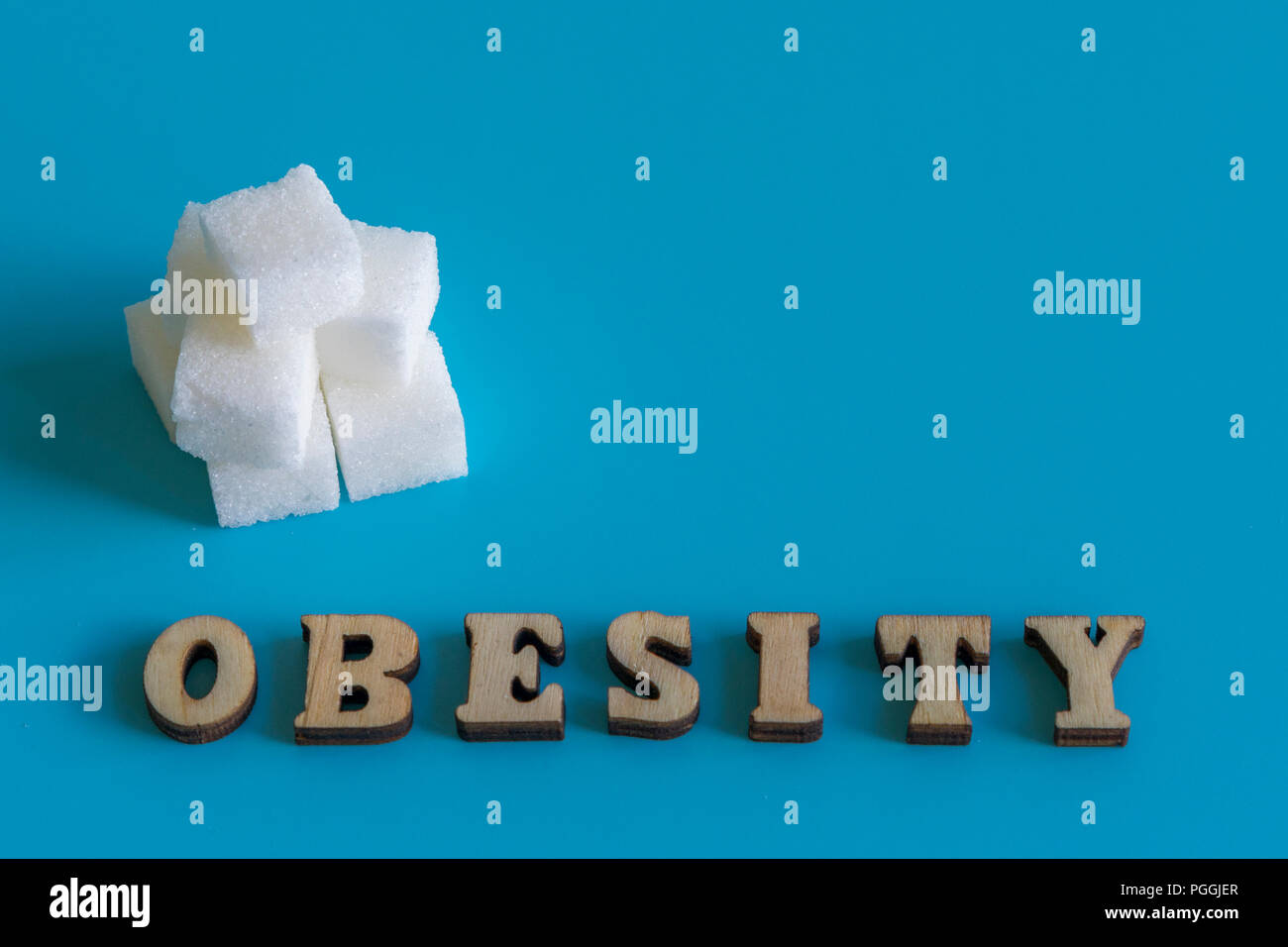 inscription obesity on a blue background. The concept of obesity from ...