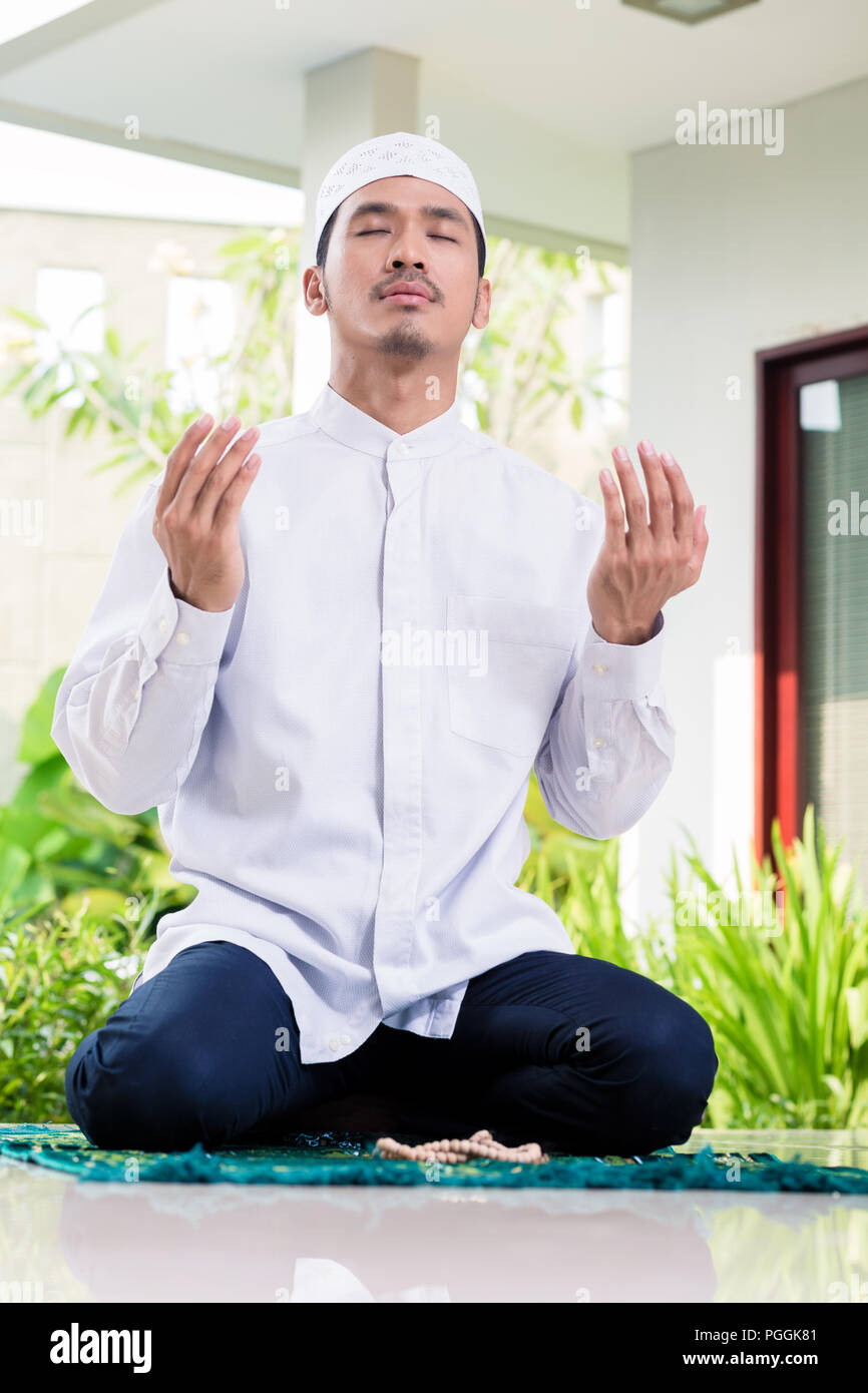 Asian Muslim man praying at home Stock Photo - Alamy
