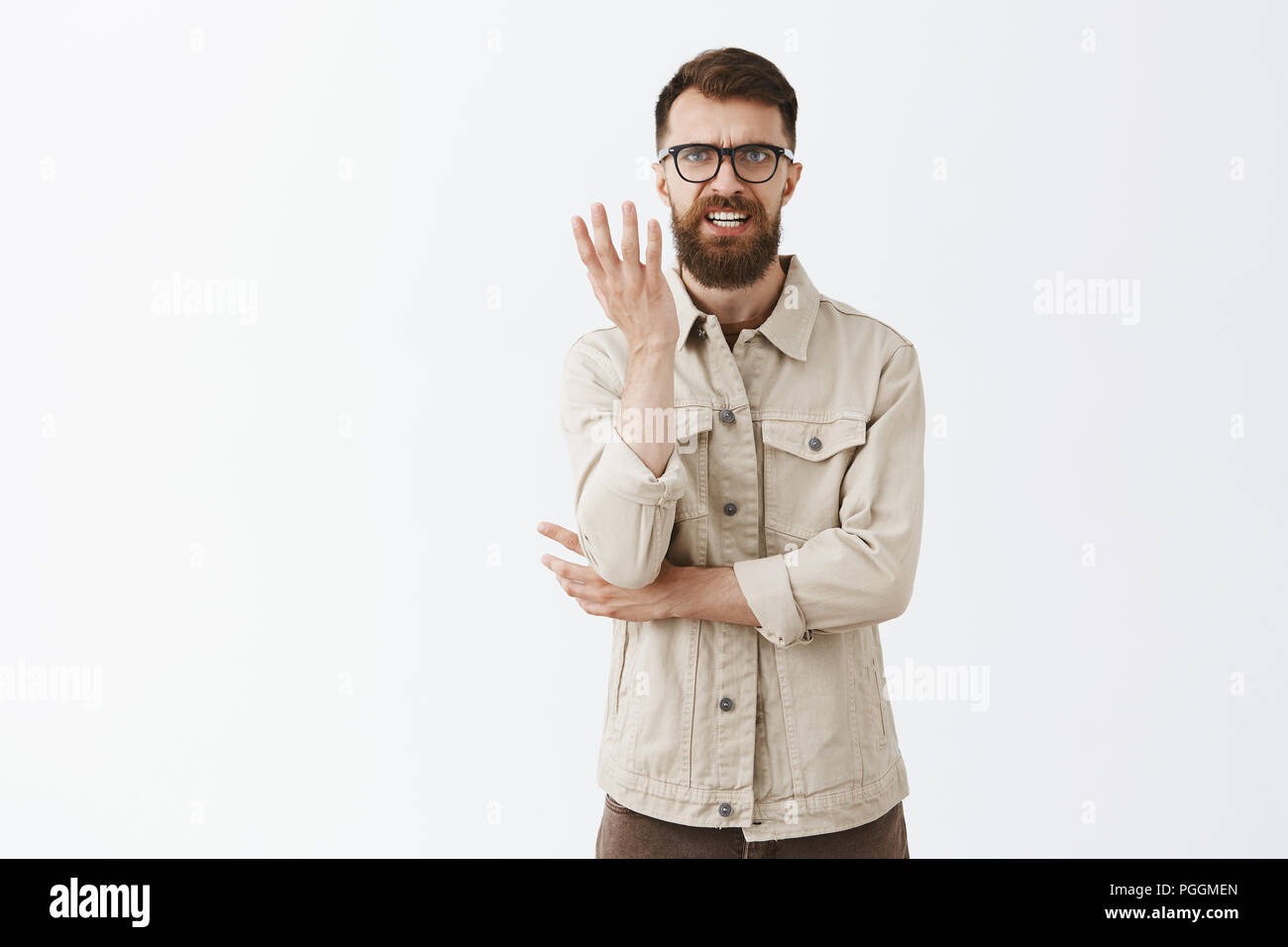 Angry and confused displeased mad european guy with long beard in black ...