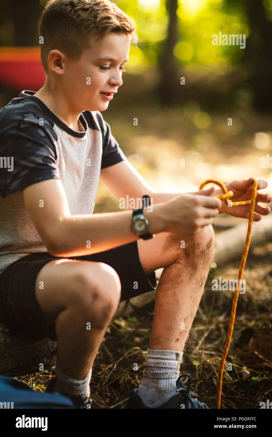 Boy tying knots in rope Stock Photo - Alamy