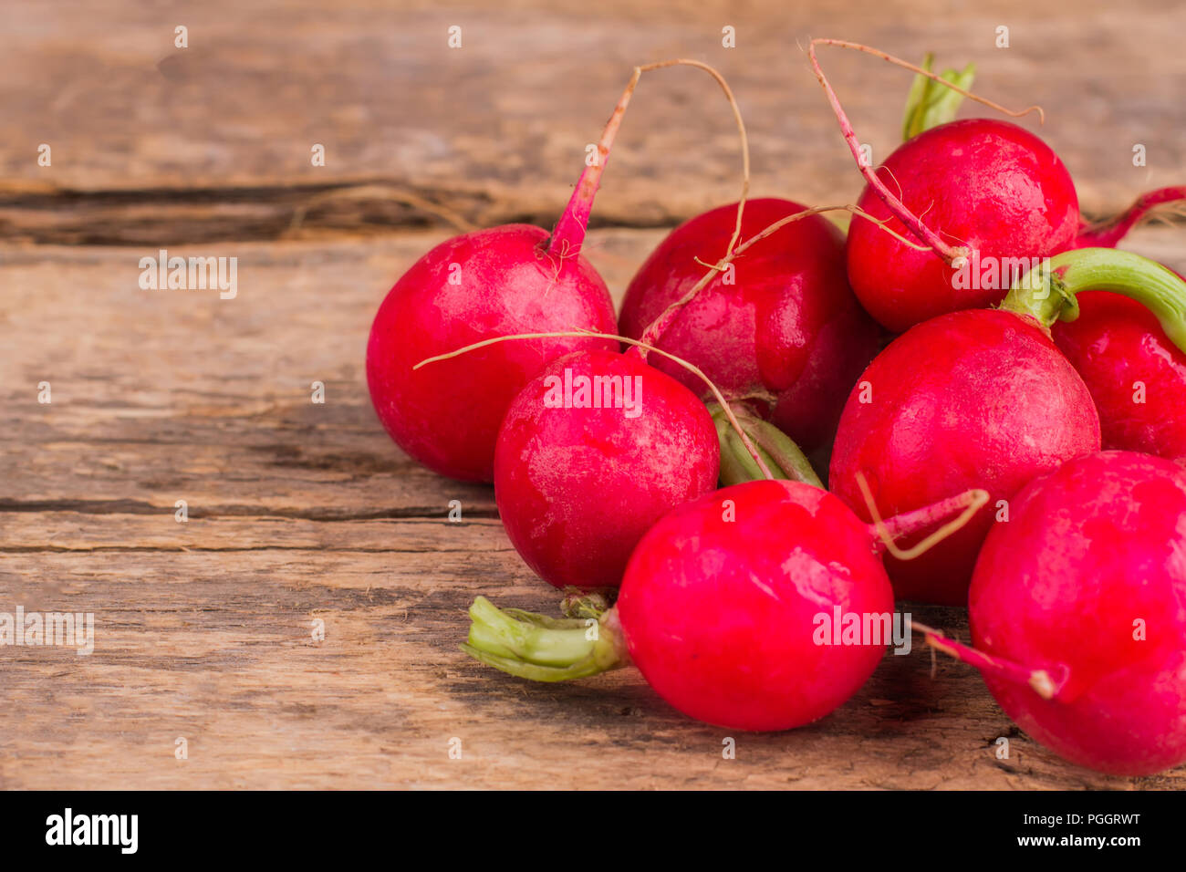 Pile of multiple radishes. Close up. Old vintage wooden desk table ...