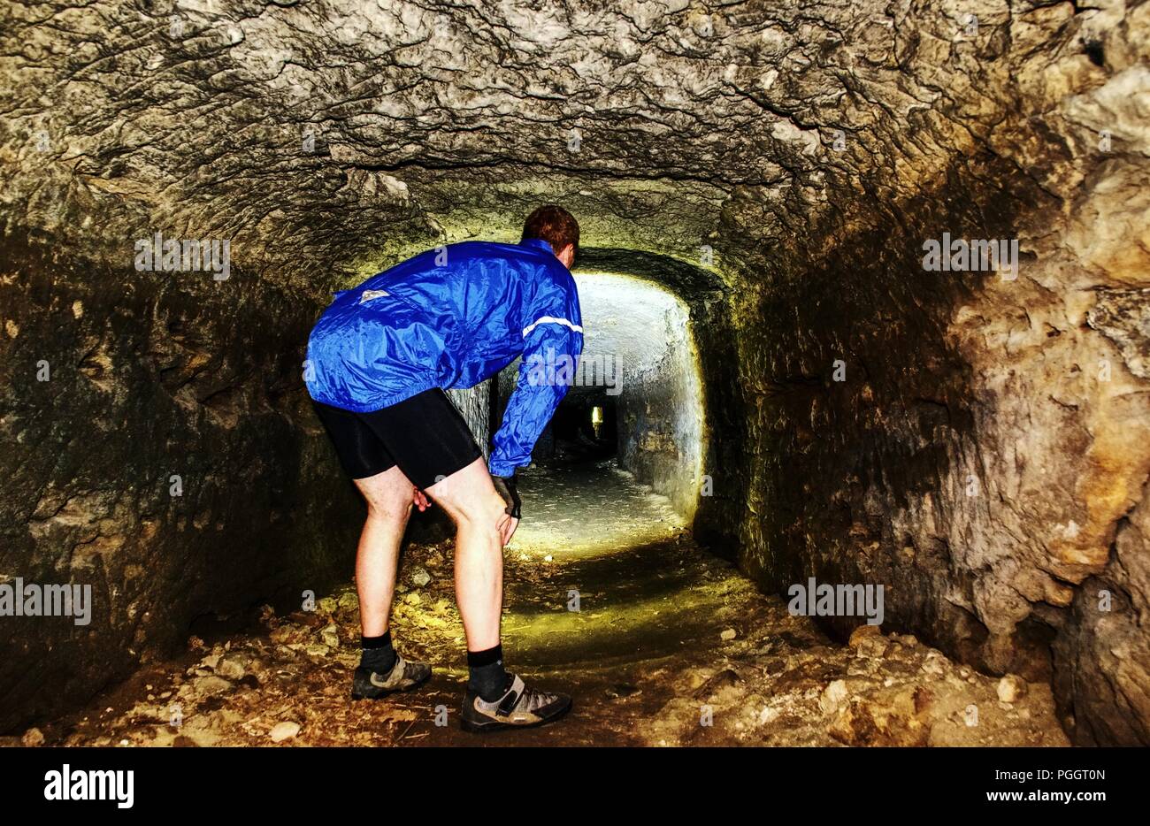 Man walk in low mystical ancient tunnel from orange sandstone. City ...