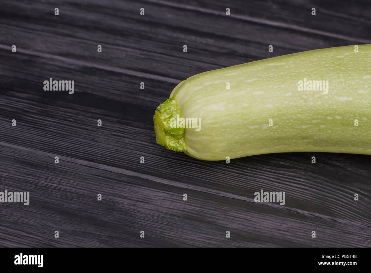 Bright courgette close up. Dark black wooden table background Stock ...