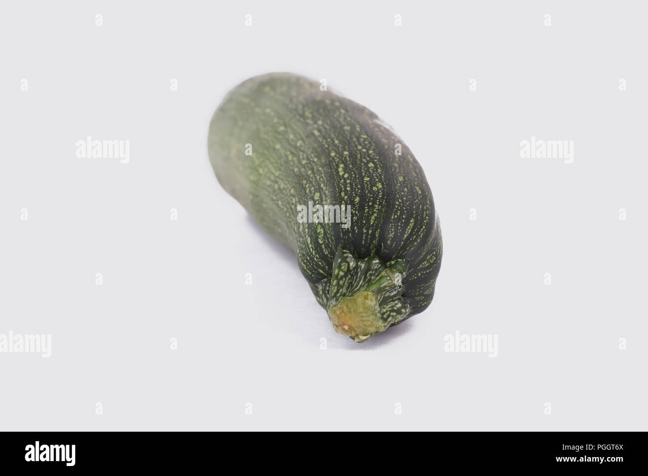 One single green organic zucchini close up. White isolated background ...