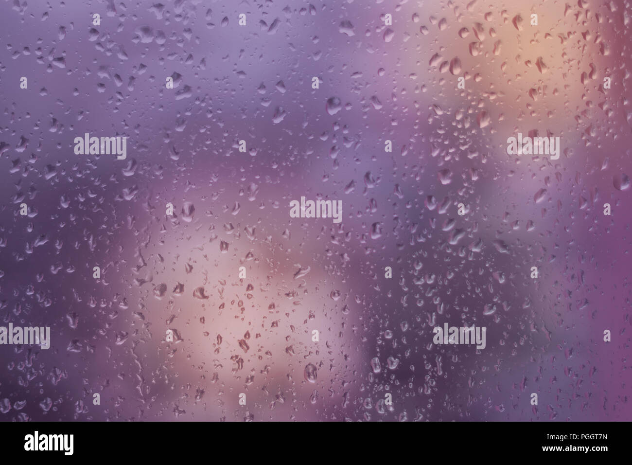 Abstract violet and orange background, texture of rain drops on glass ...