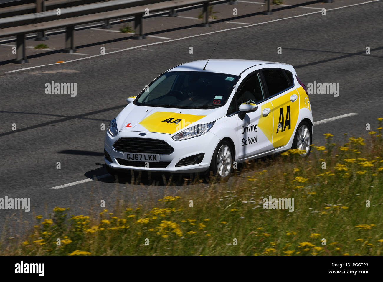 AA driving school car driving down a dual carriageway Stock Photo - Alamy