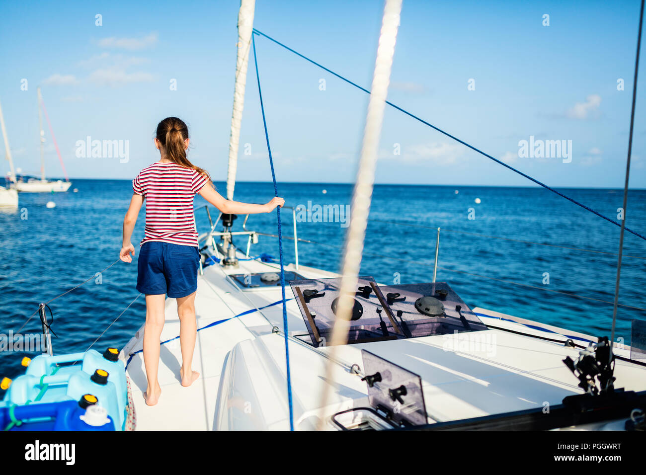 Adorable little girl enjoying sailing on a luxury catamaran or yacht ...