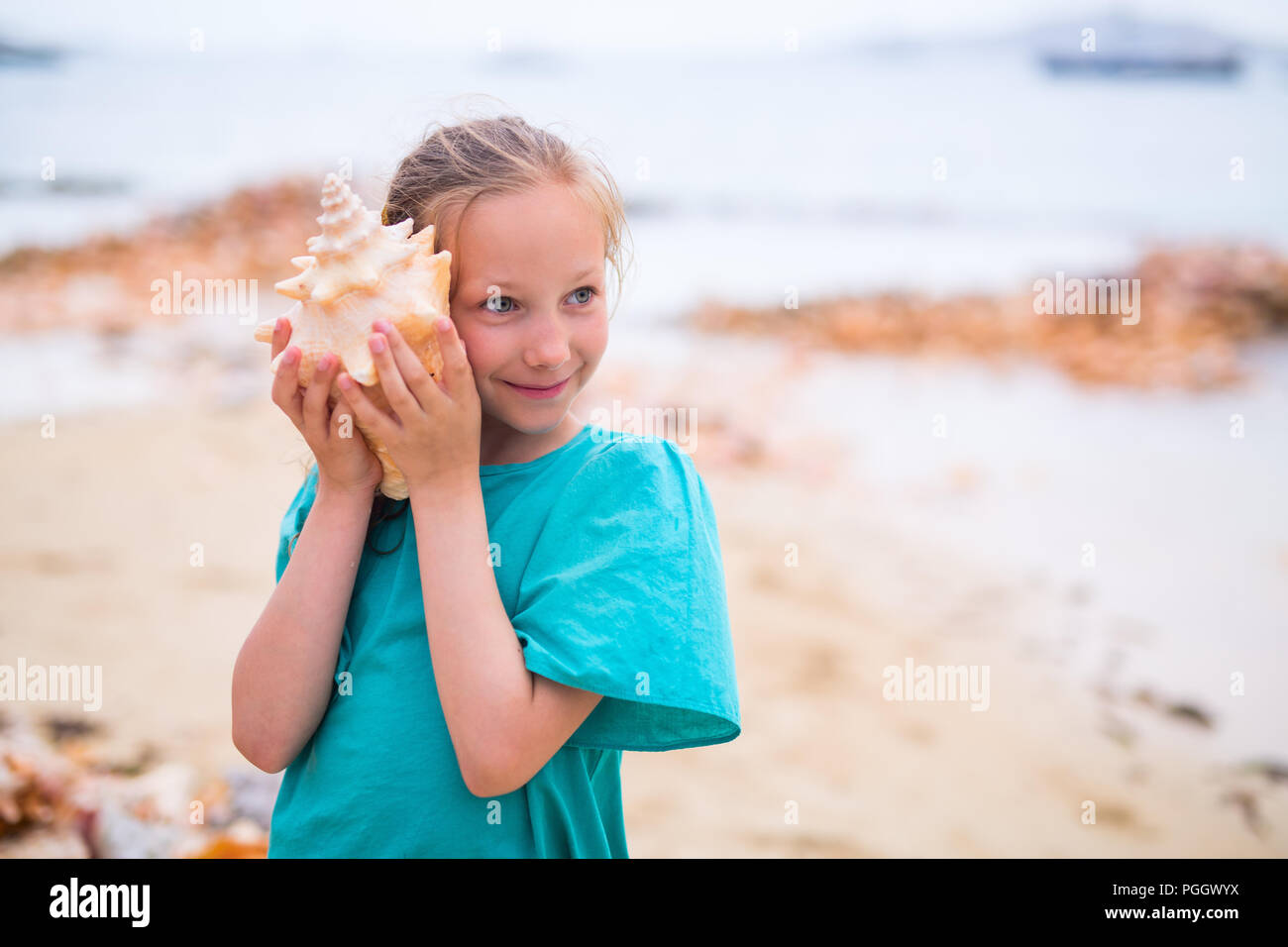 Girl listening to seashell hi-res stock photography and images - Alamy