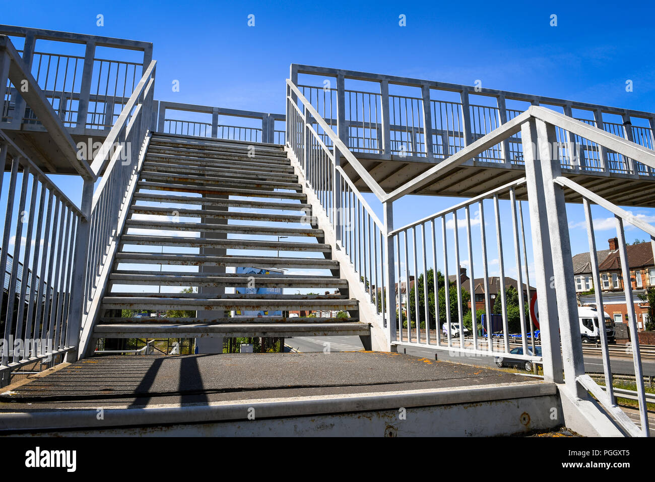 A metal stairway heading up to a footbridge crossing a busy road Stock ...