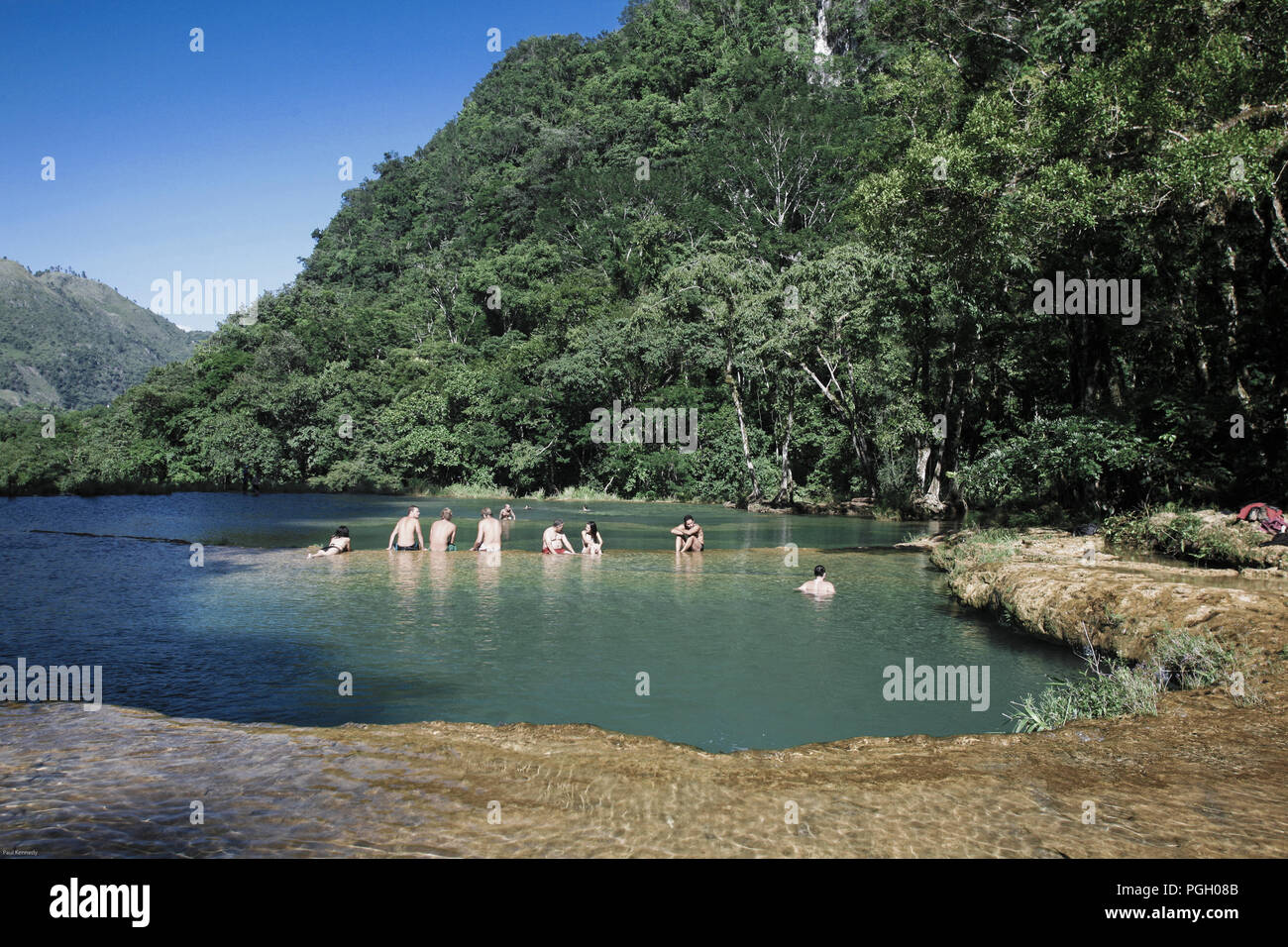 Tourists enjoy the cool water turquoise pools of Semuc Champey ...