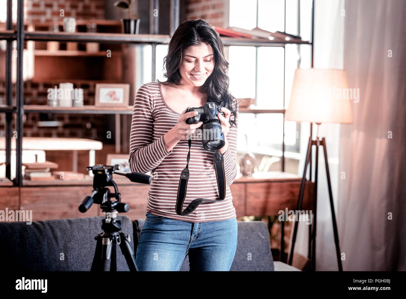 Joyful woman looking through photos on her cam Stock Photo - Alamy