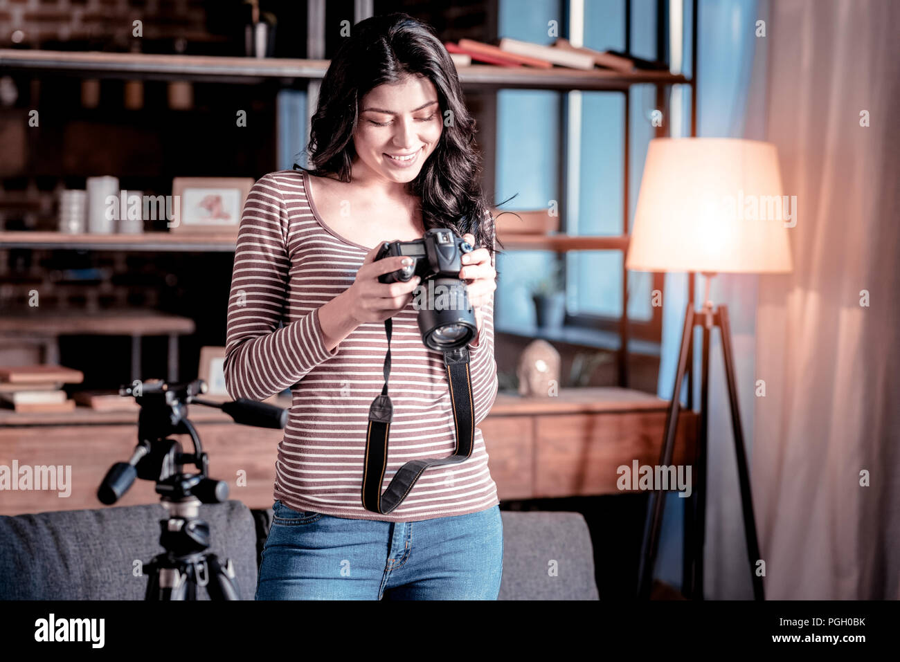 Happy woman looking through photos on her cam Stock Photo - Alamy