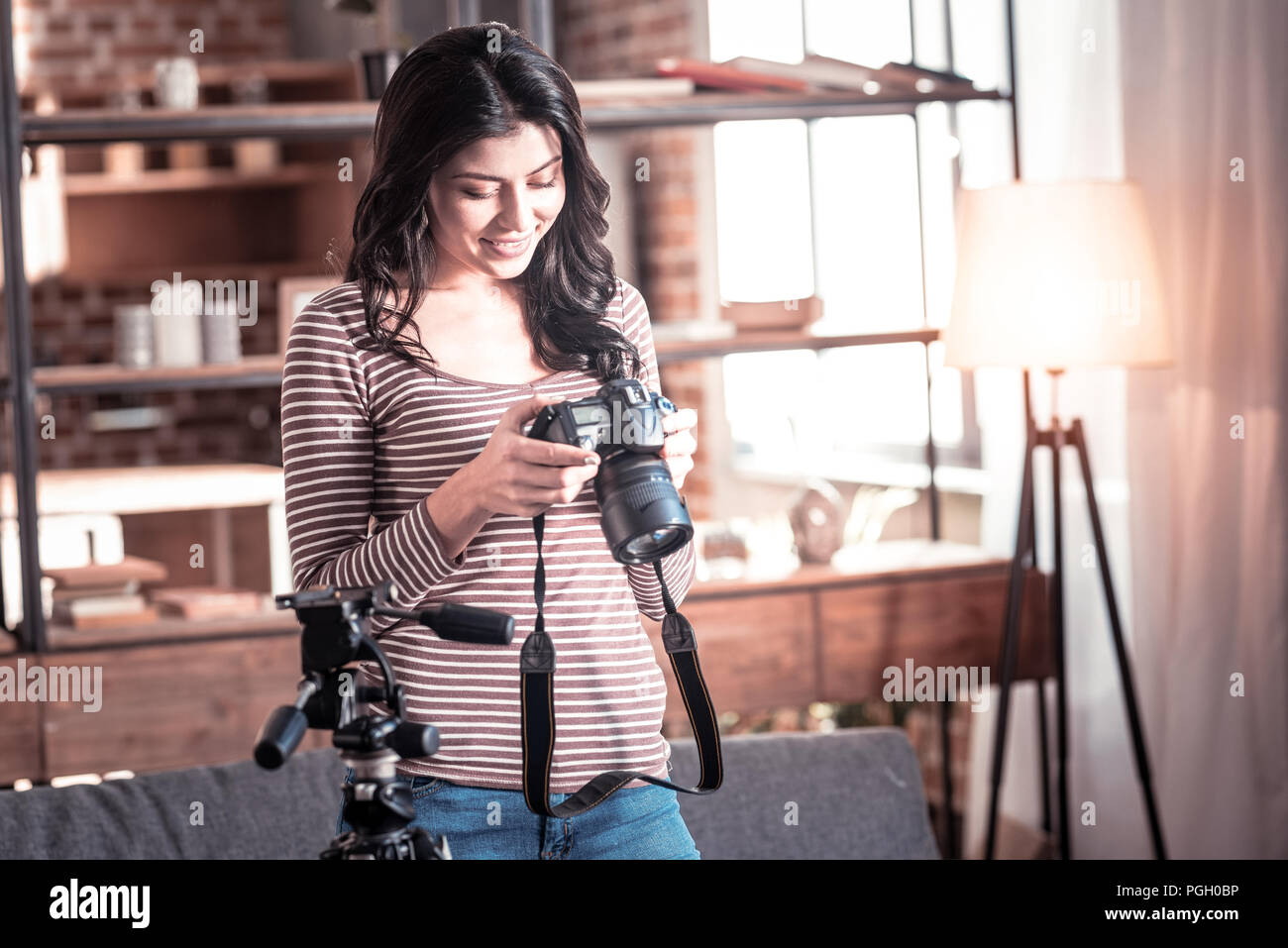 Content woman looking through photos on her cam Stock Photo - Alamy