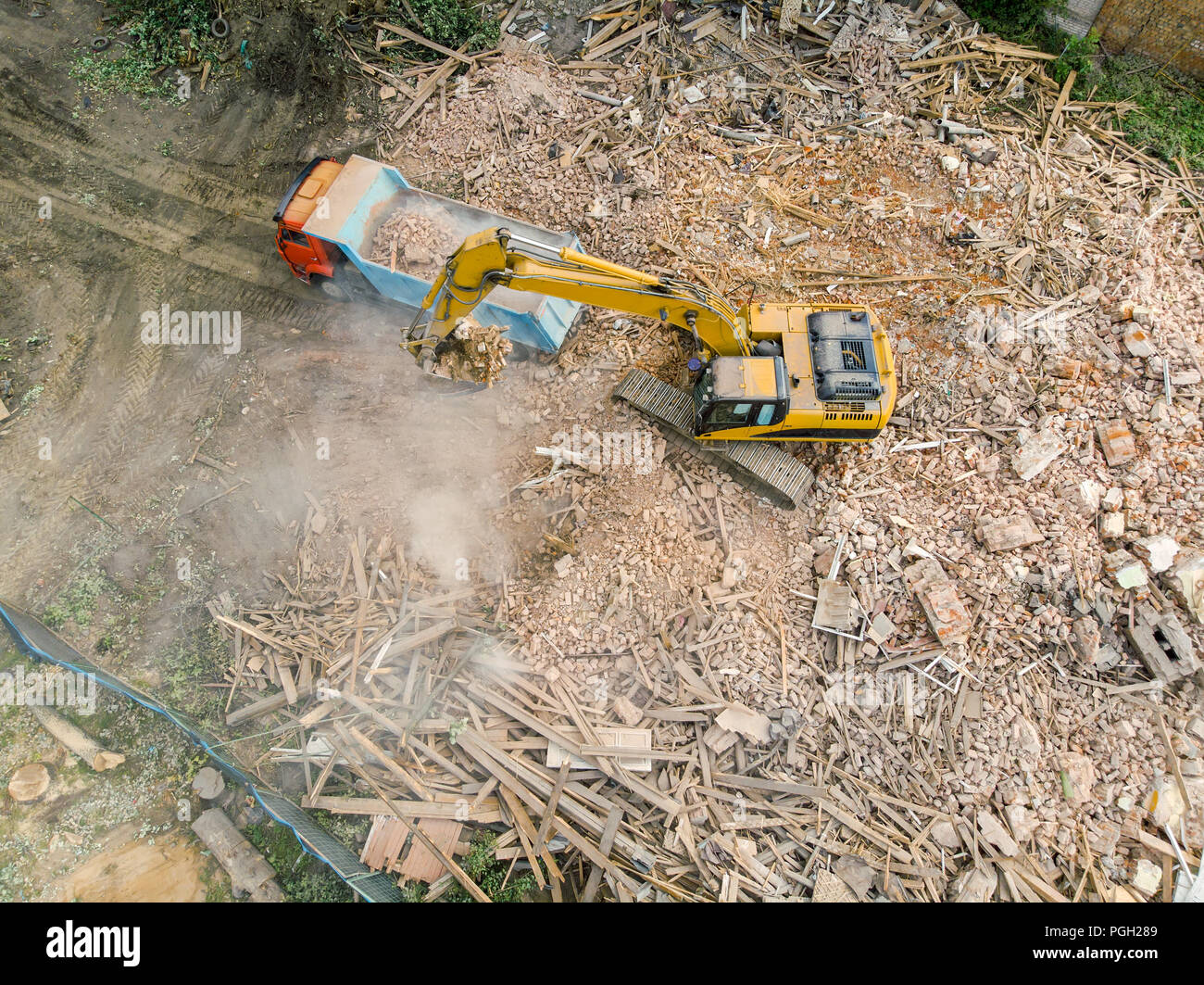 dumper truck and excavator working at the demolition site in ruins ...