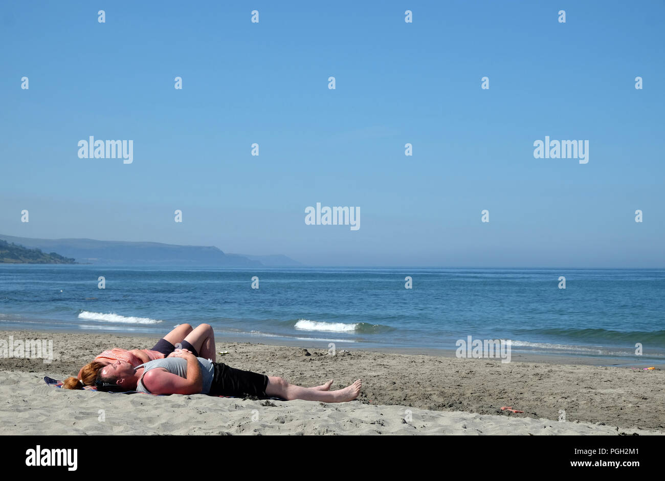 Couple sunbathing at the beach hi-res stock photography and images - Alamy