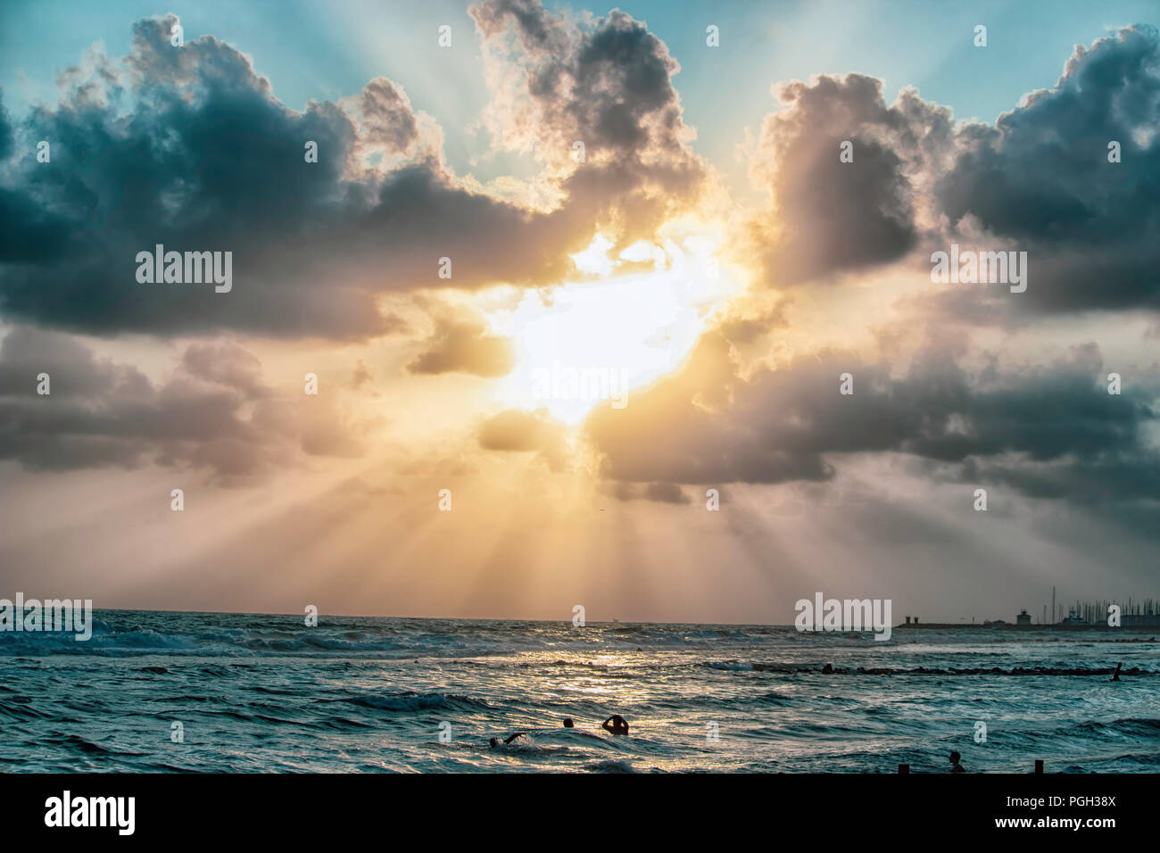 Sun beams trough the clouds in a cloudy sunset Stock Photo - Alamy