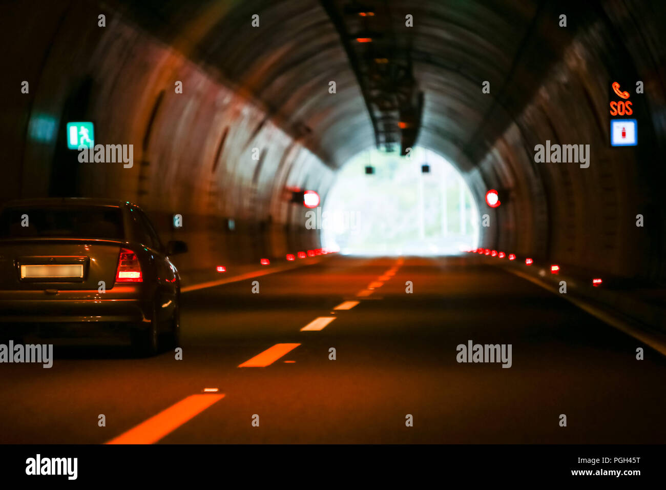 Two lines highway tunnel with one car driving on the right line to the ...