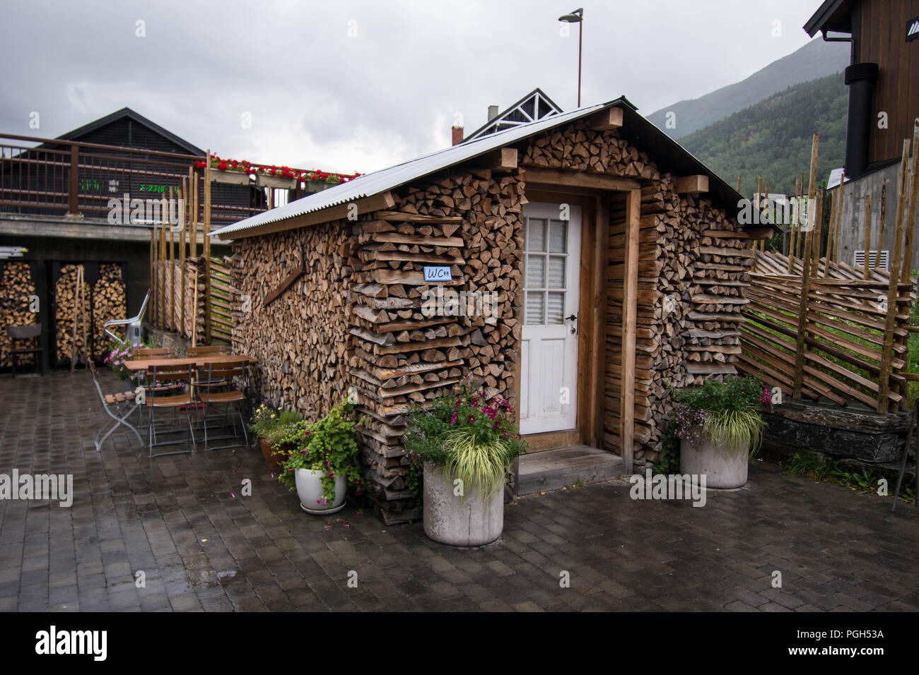 Norway plant pots plants log cabin wood logs outside view wet raining ...