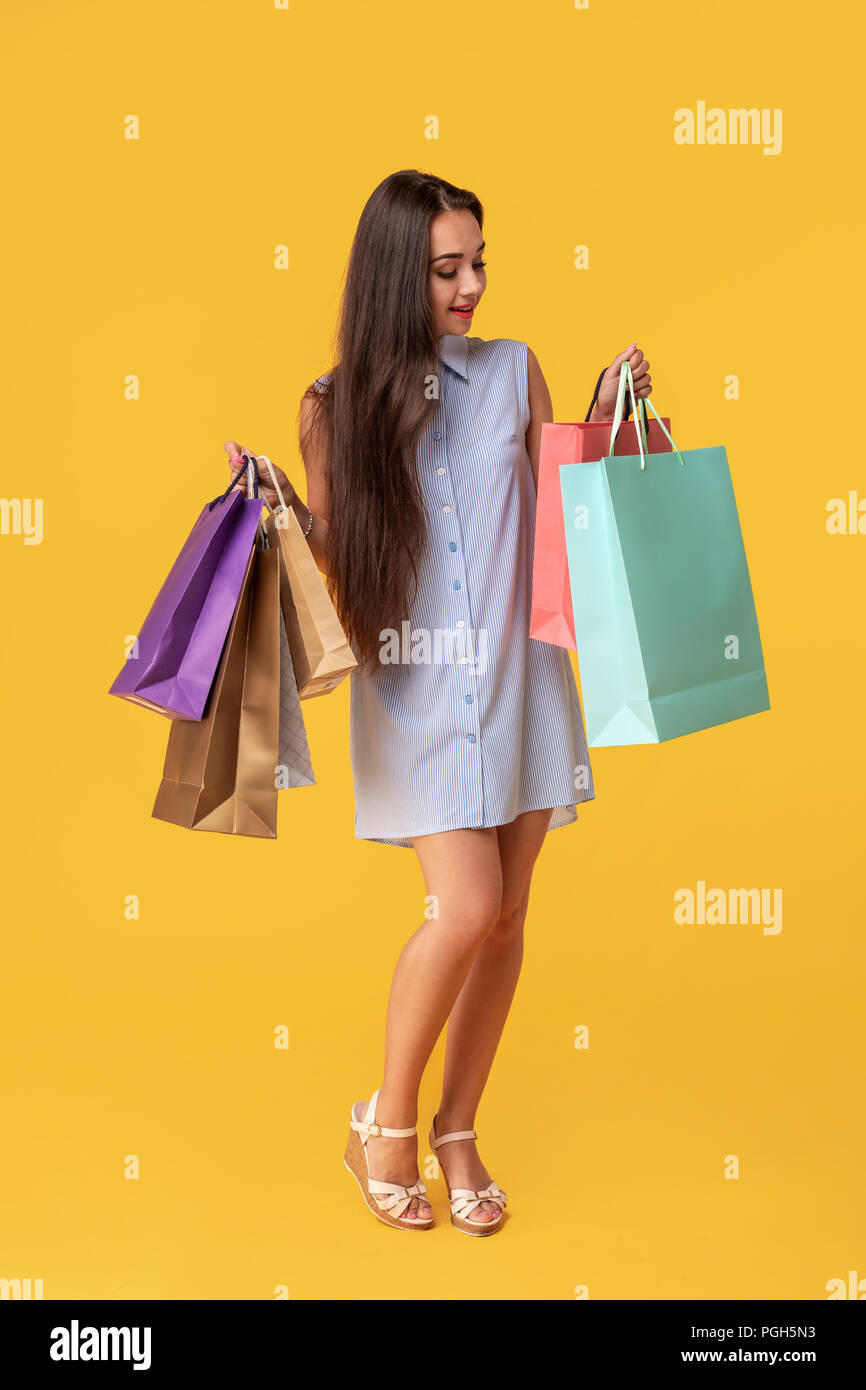 Full length photo of young woman in dress looking back on copy space ...