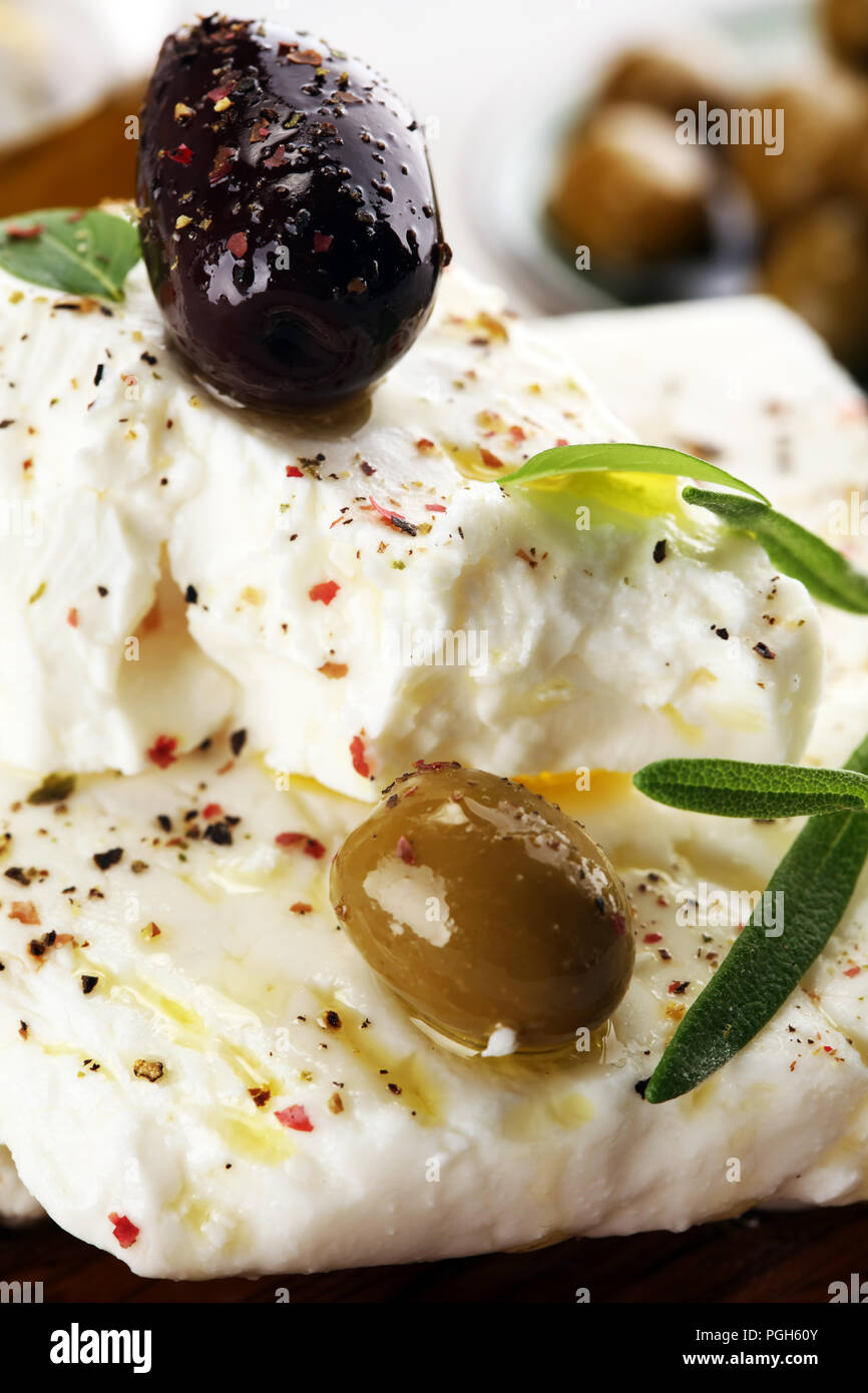 Greek cheese feta with herbs and olives on rustic table Stock Photo - Alamy
