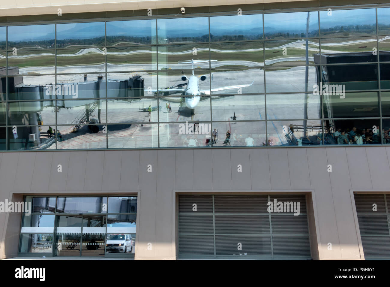 Reflection of passenger jet airplane in glass windows of airport ...