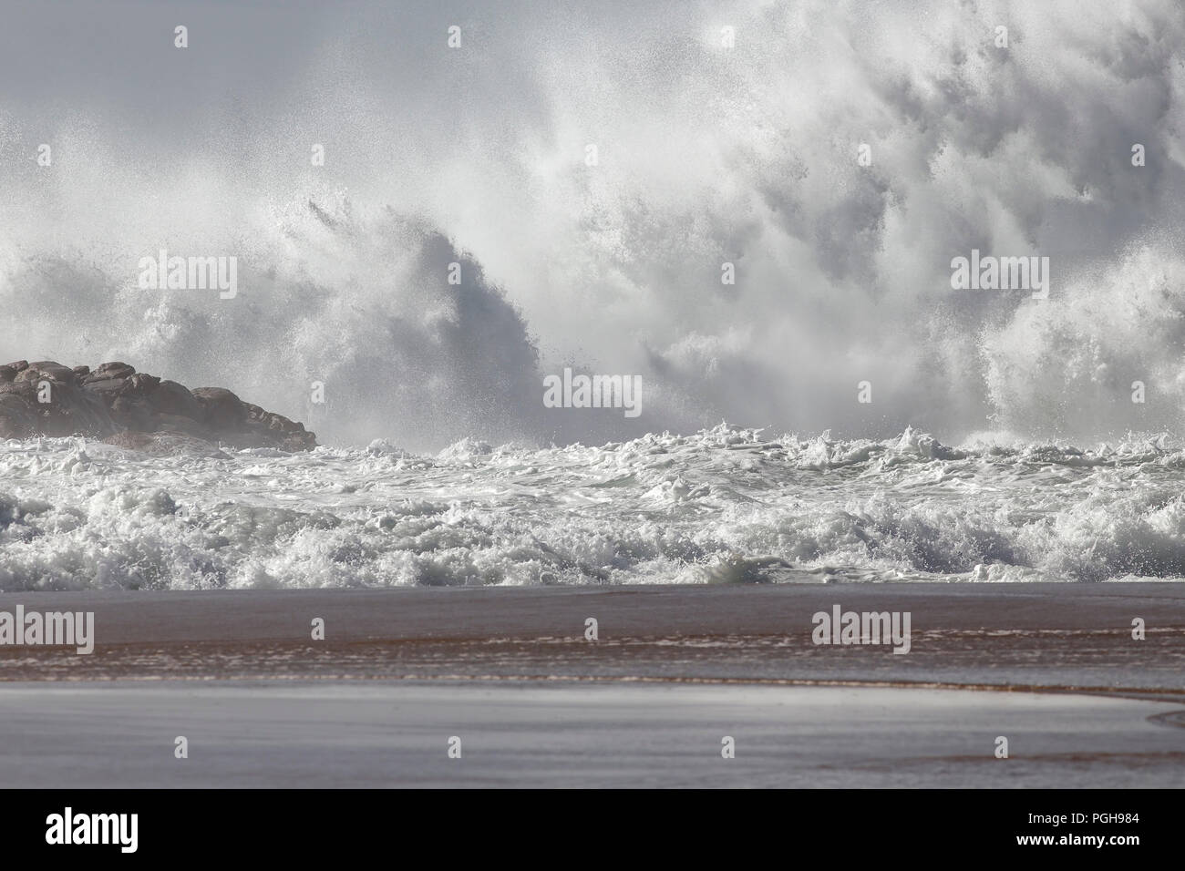 Huge splash from a stormy breaking wave in an empty beach from the ...