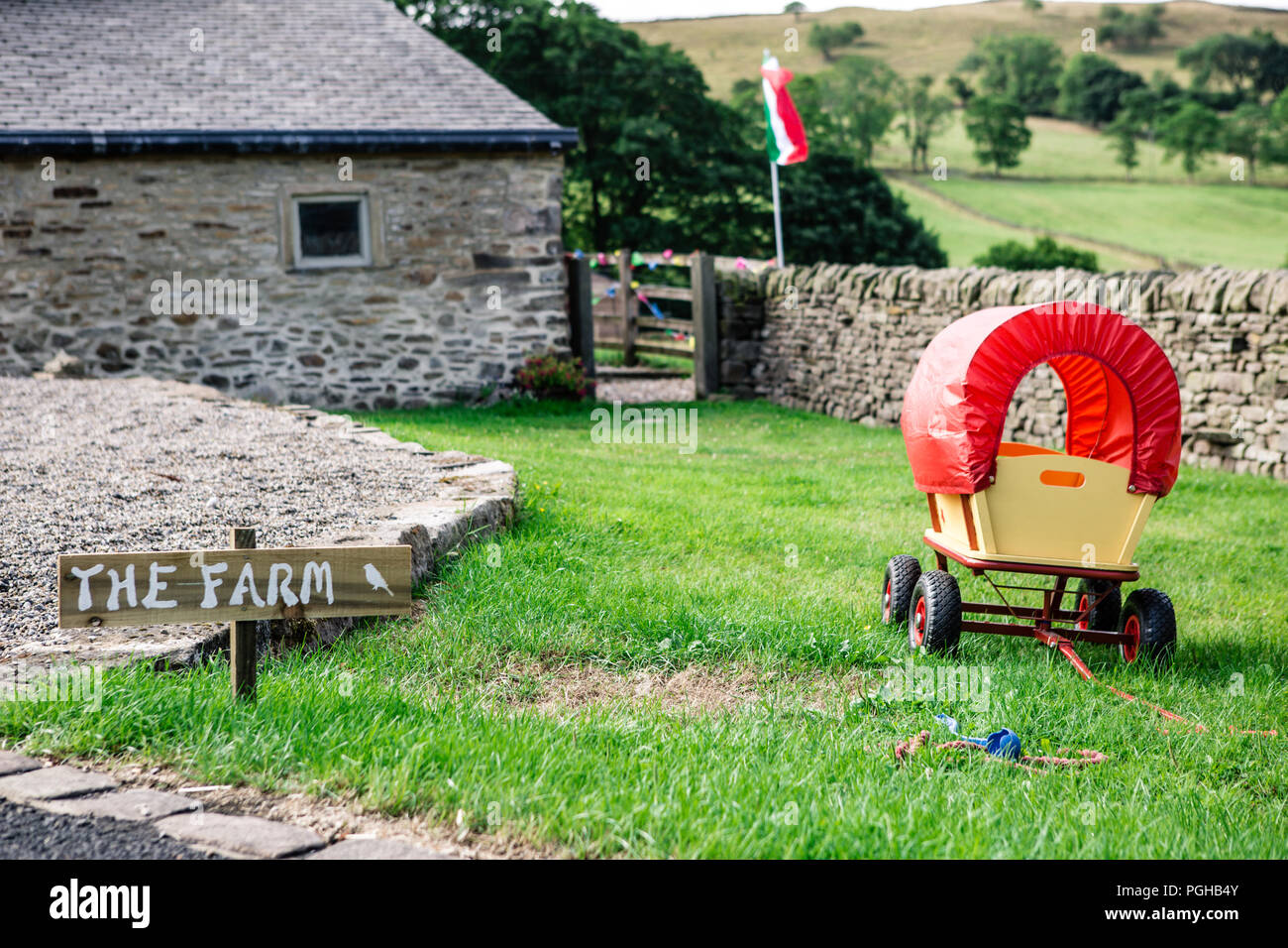 Colourful wooden children's cart in garden of English farmhouse Stock ...