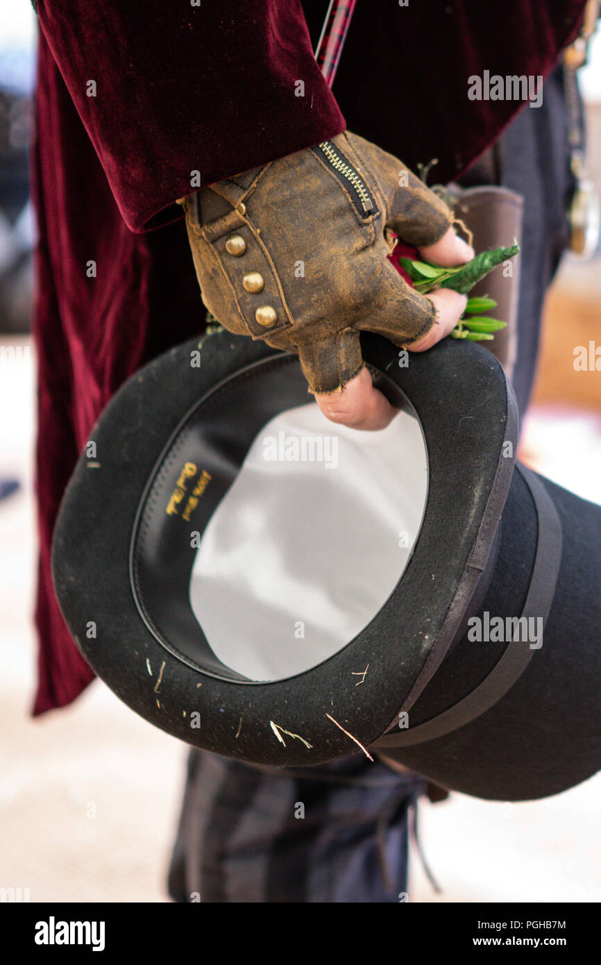 close up of mans hand holding top hat and finger less glove at ...