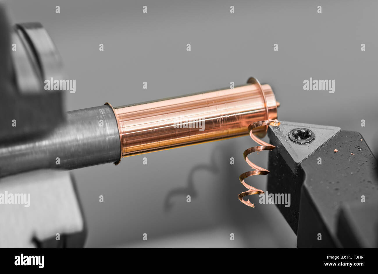 Tool bit detail working on lathe. Close-up of bronze workpiece clamped ...